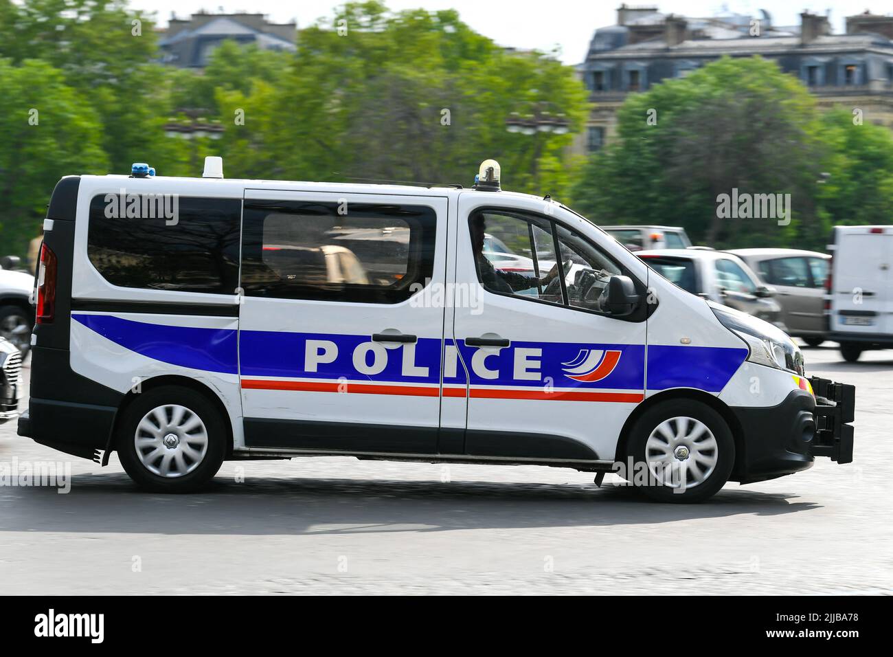 A police car (truck, van) drives through the city ensuring security in ...