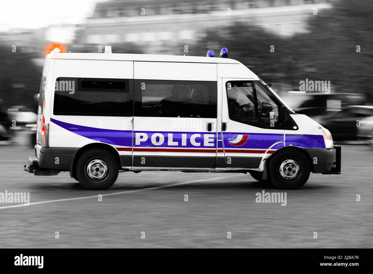 A police car (truck, van) drives through the city ensuring security in ...