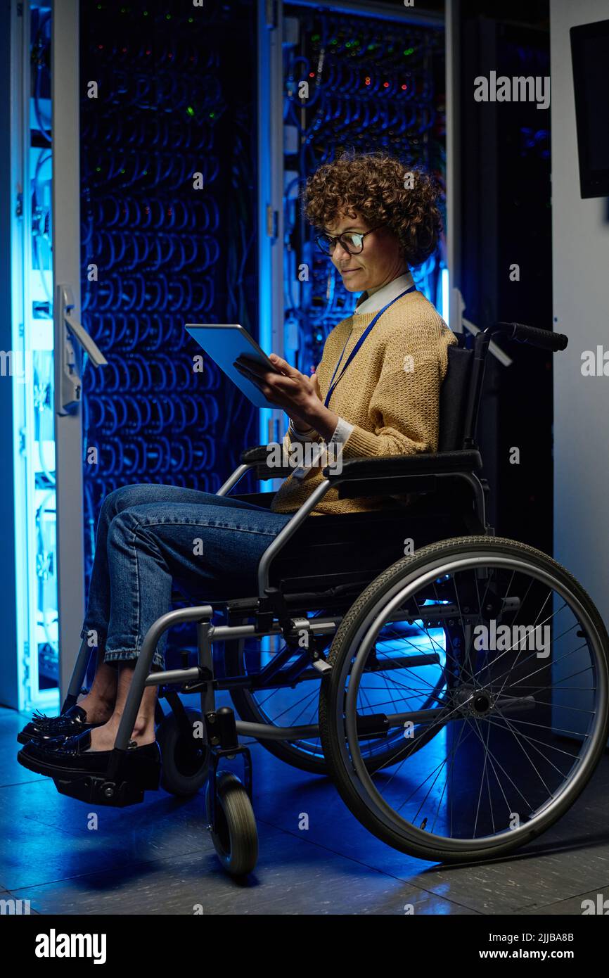 Female system admin with disability using computer while setting up server network Stock Photo ...