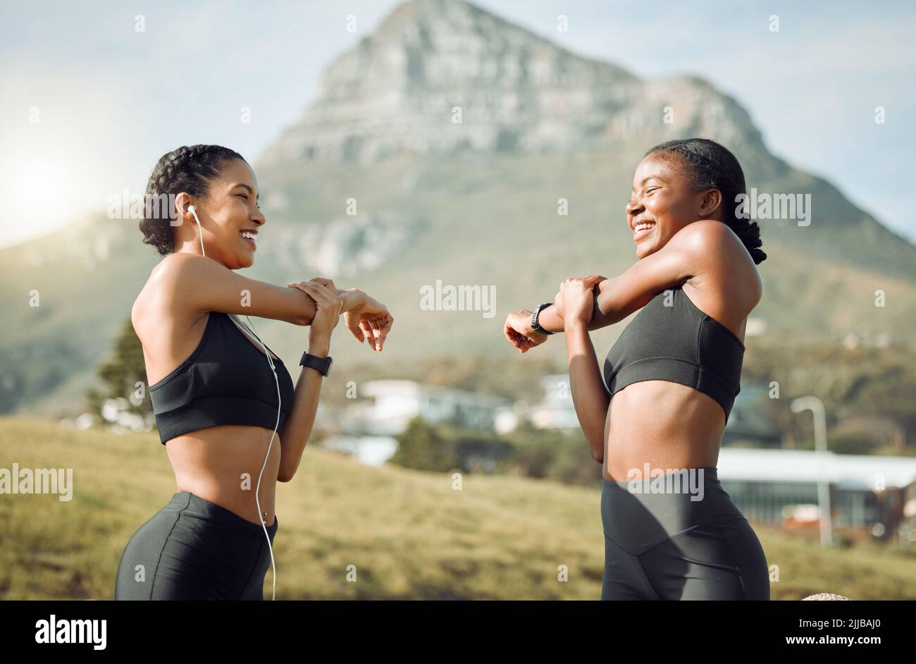 A cheeky little catch up. two friends stretching before a run Stock ...