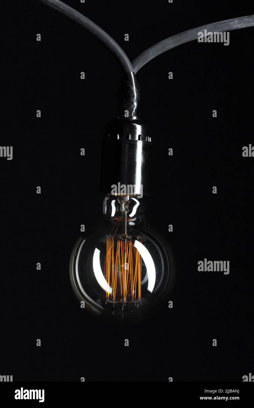 A classic Edison light bulb on dark background with space for text ...