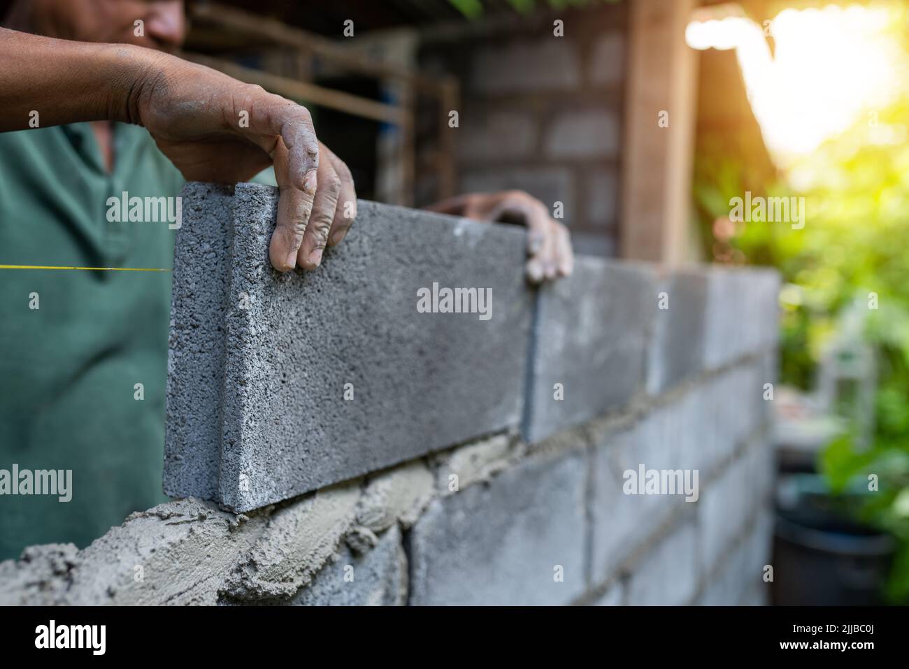 Close-up hands worker use brick block construction Stock Photo - Alamy