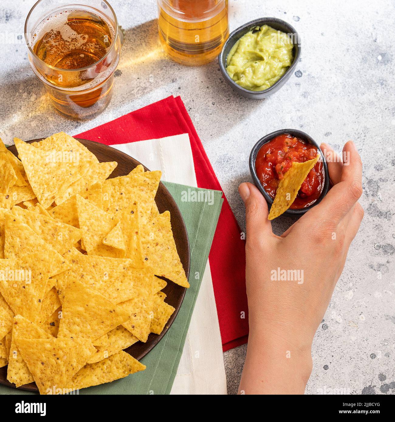 Famous Mexican snack, nachos with guacamole, red chilli sauce and beer ...