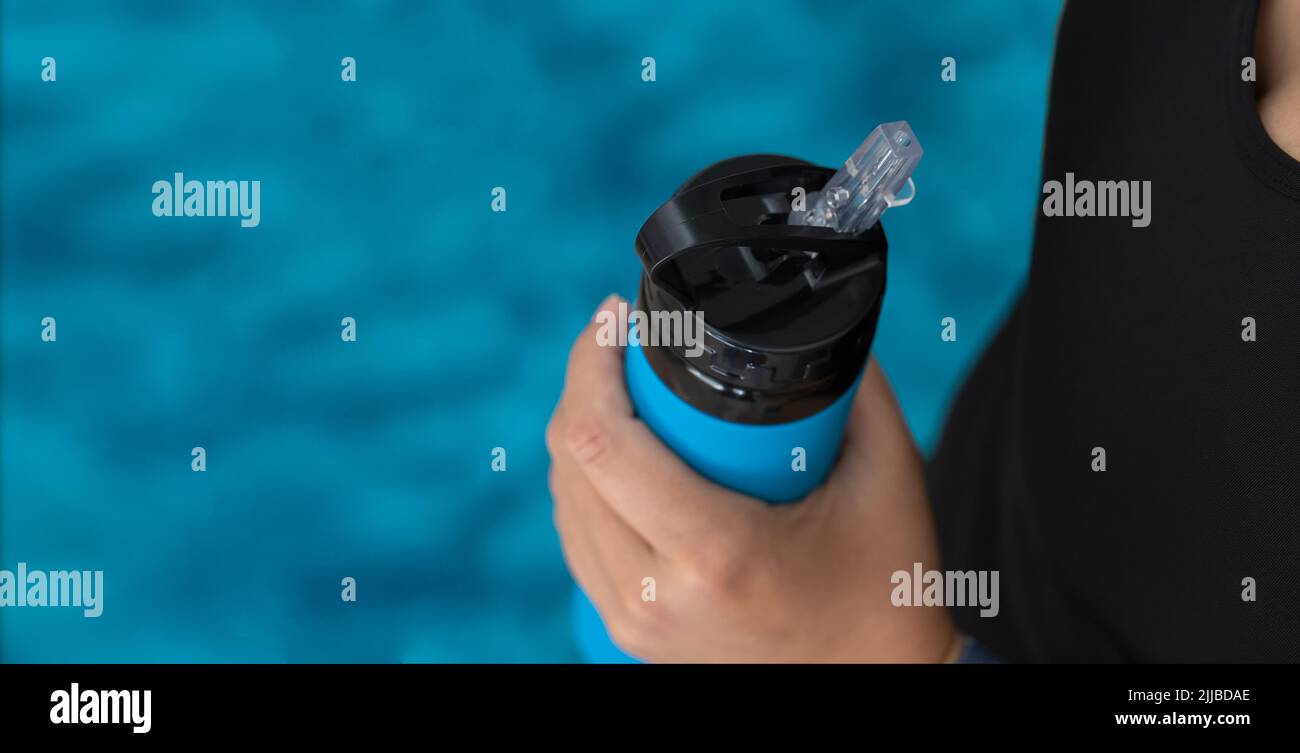 Female hands holding sports bottle. Drinking water during exercise ...