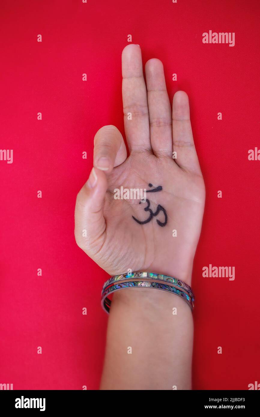 Hands in Gyan Mudra yoga gesture with OM symbol paited on it. Red ...