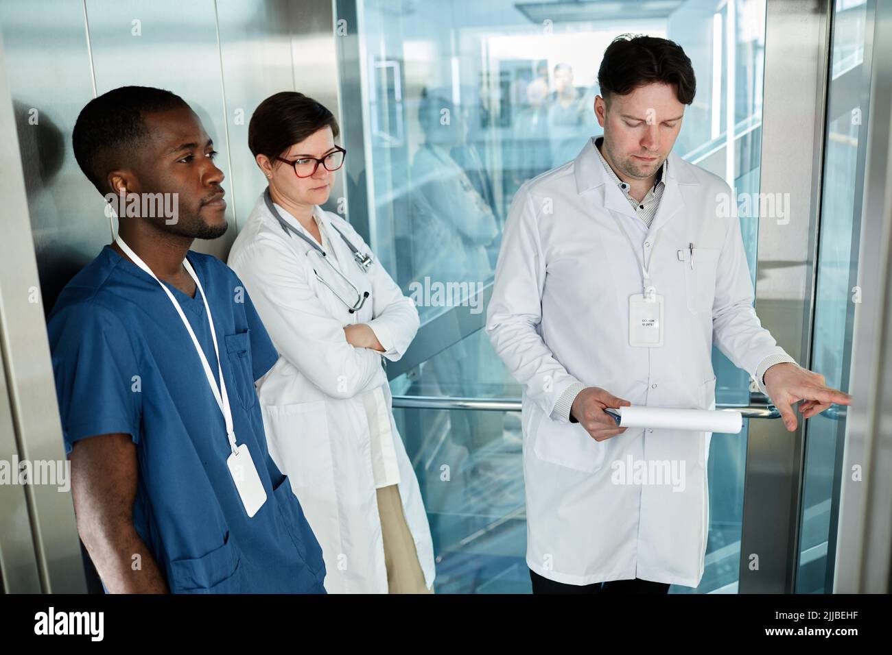 Diverse group of doctors in elevator at modern hospital building Stock ...