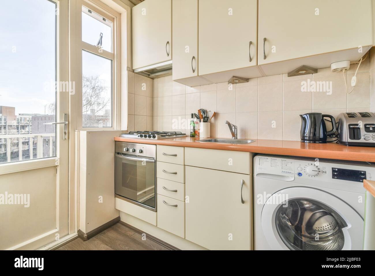 Fragment of interior of light narrow home kitchen with minimalist style ...