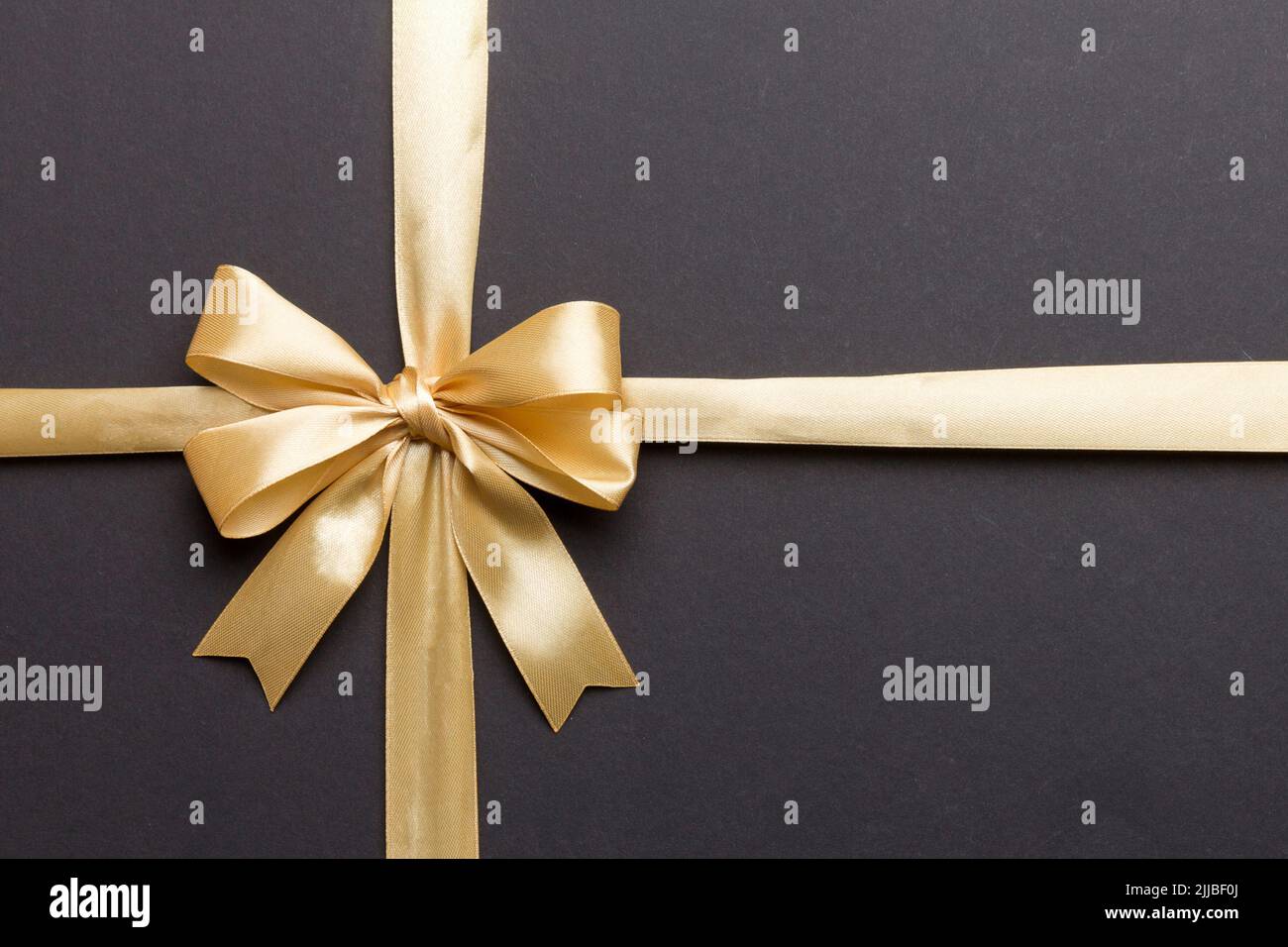 Top view of gold ribbon rolled and yellowbow isolated on colored ...