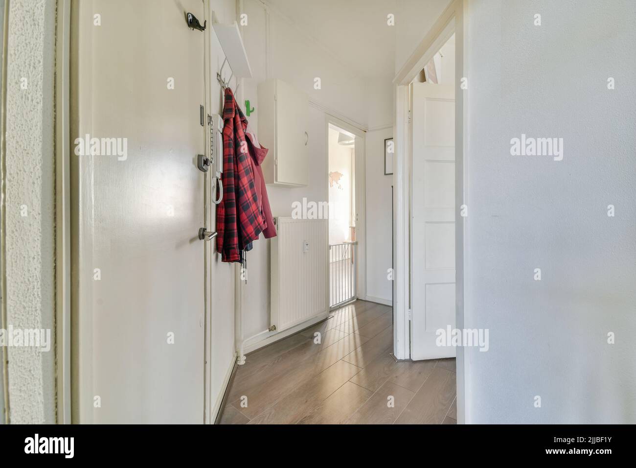Light narrow hallway with many doors in white walls and glowing lamp ...