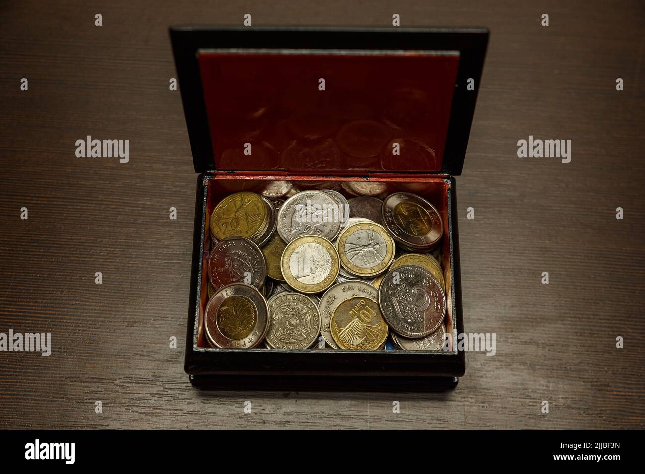 Open casket with coins from different countries. Keeping coins in a box ...