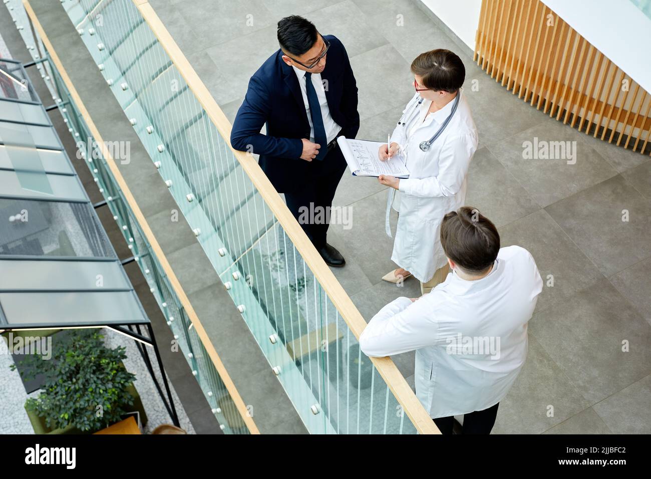 Graphic top down view at doctors discussing case while standing at ...