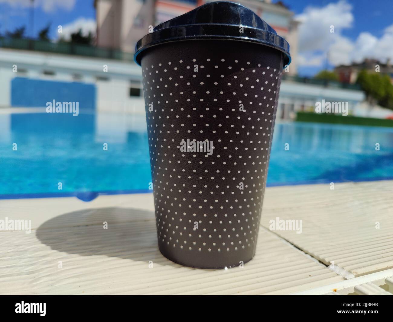 A reusable cup of coffee by the swimming pool Stock Photo - Alamy
