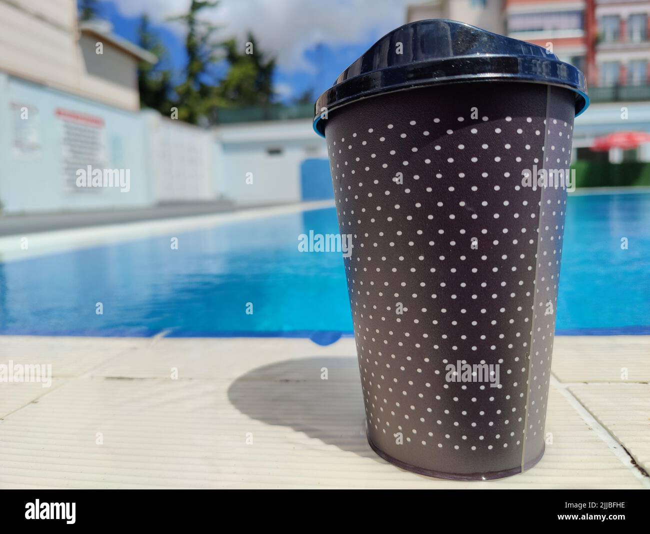A reusable cup of coffee by the swimming pool Stock Photo - Alamy