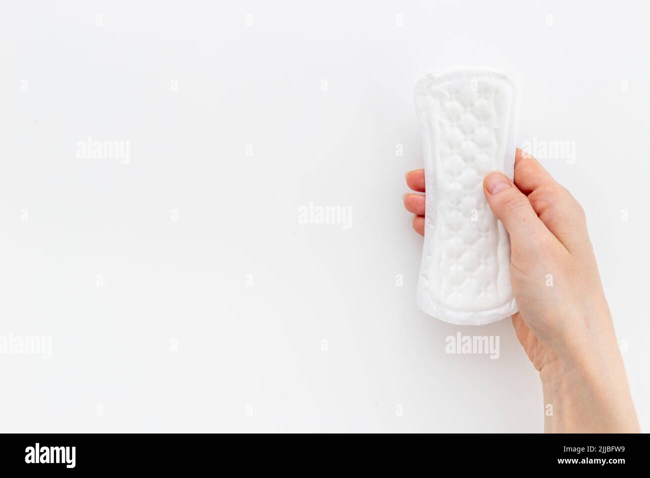 White pad in female hand. Menstruation period and daily hygiene concept ...