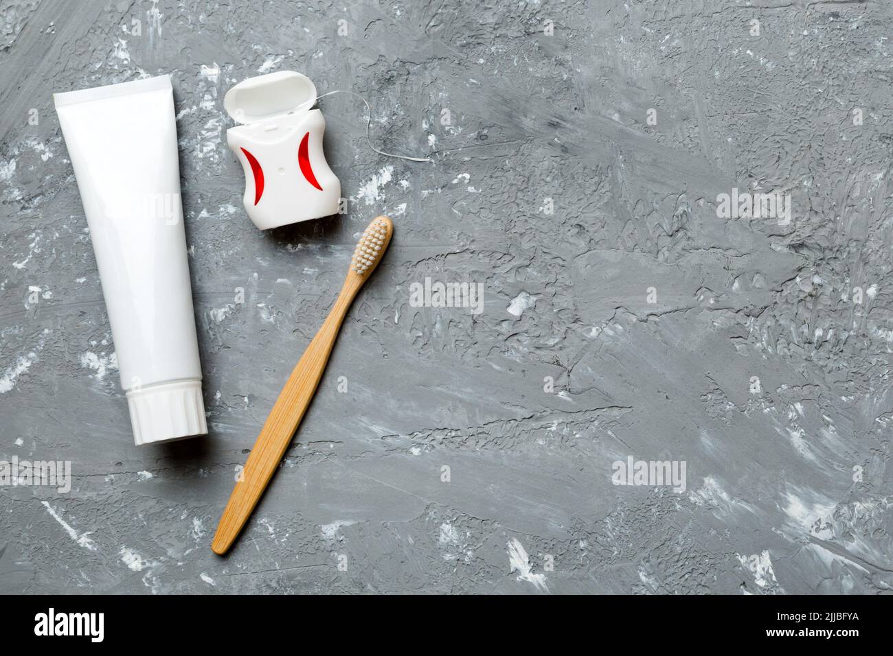 toothpaste and toothbrush top view with copy space on colored ...