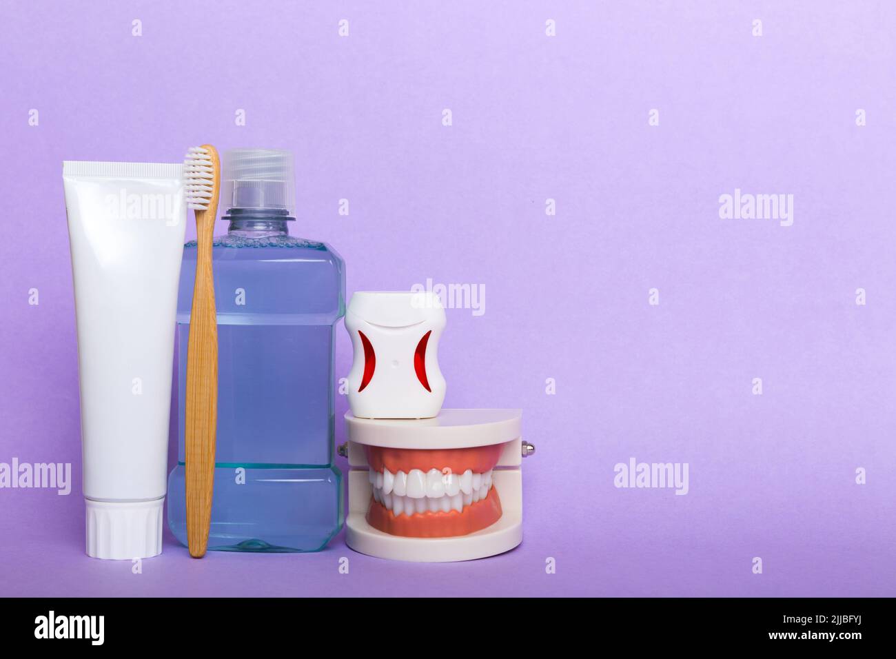 Mouthwash and other oral hygiene products on colored table top view ...