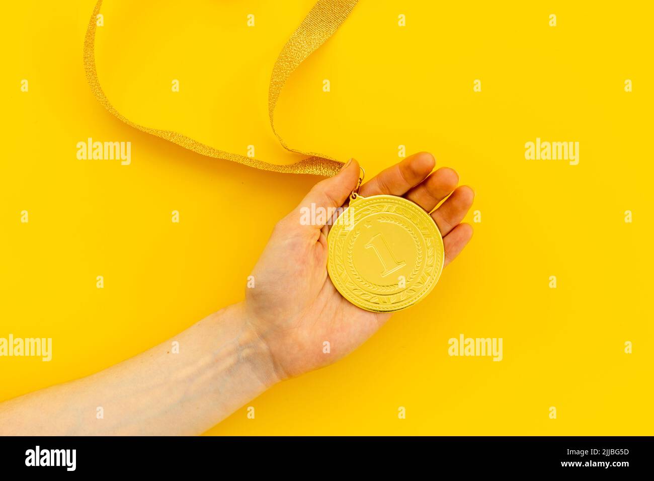 Hand holding gold medal first place. Winner of competition concept ...