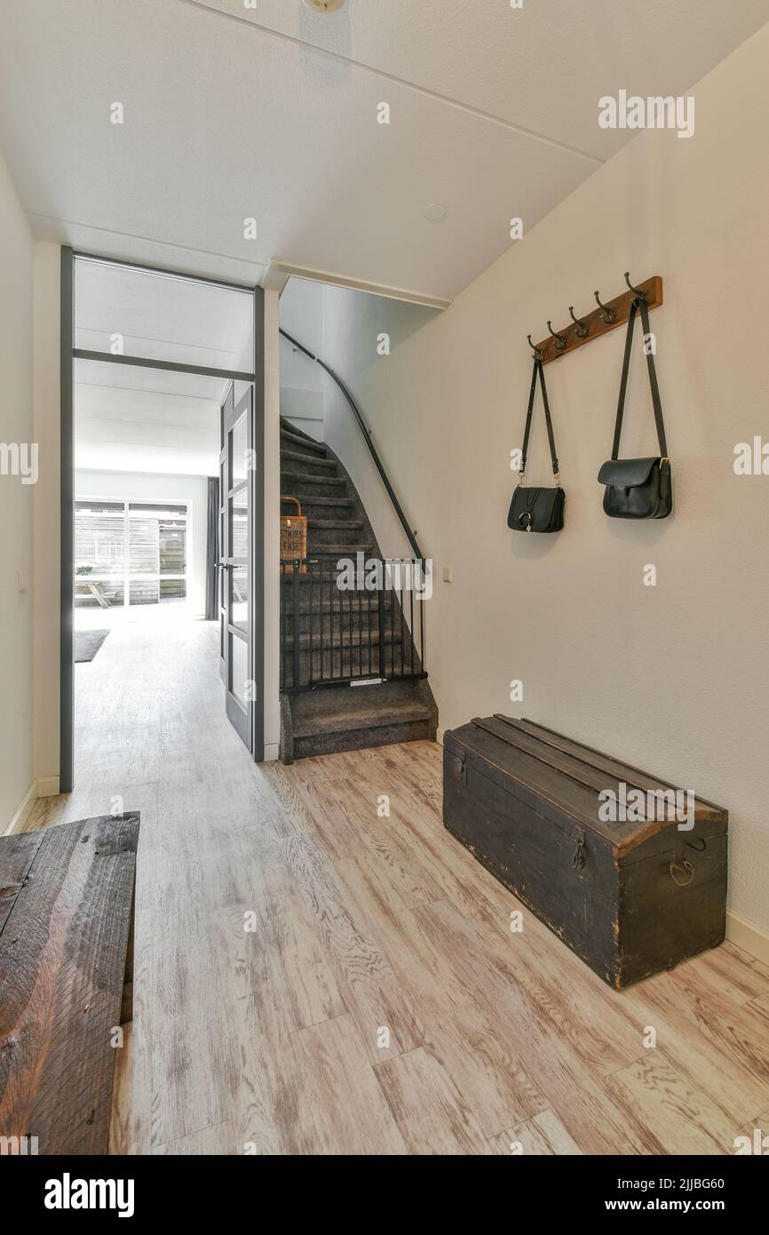 black hallway with wooden stairway leading to second floor of modern ...