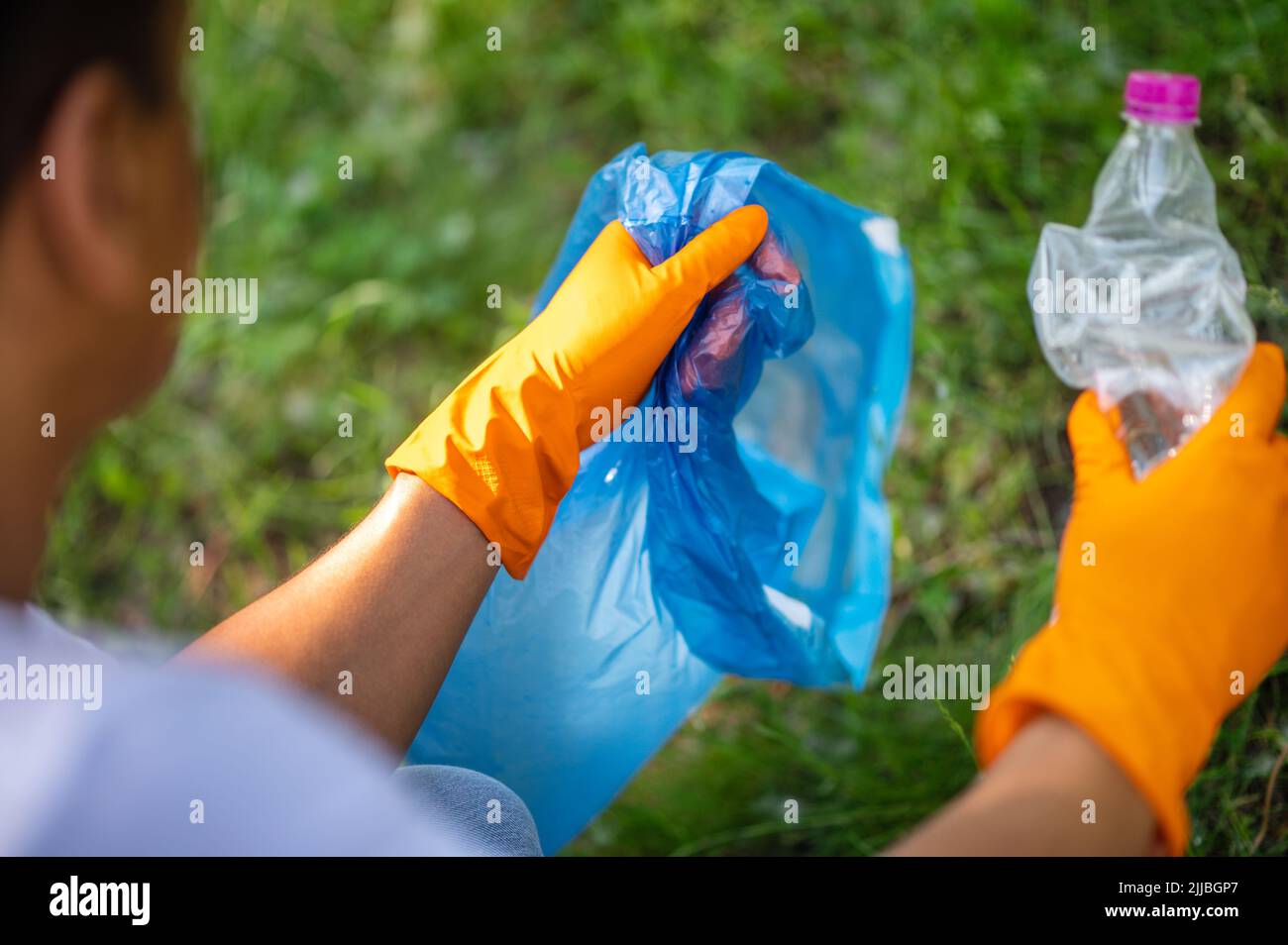 Hands of man collecting plastic in trash bag Stock Photo - Alamy