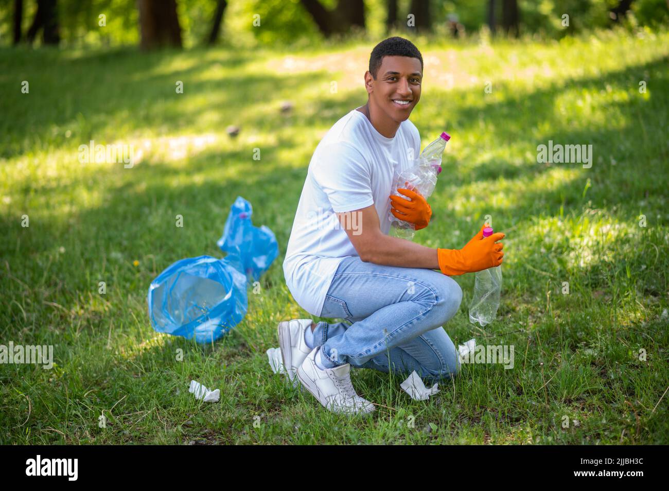 Man collecting plastic waste looking at camera Stock Photo - Alamy