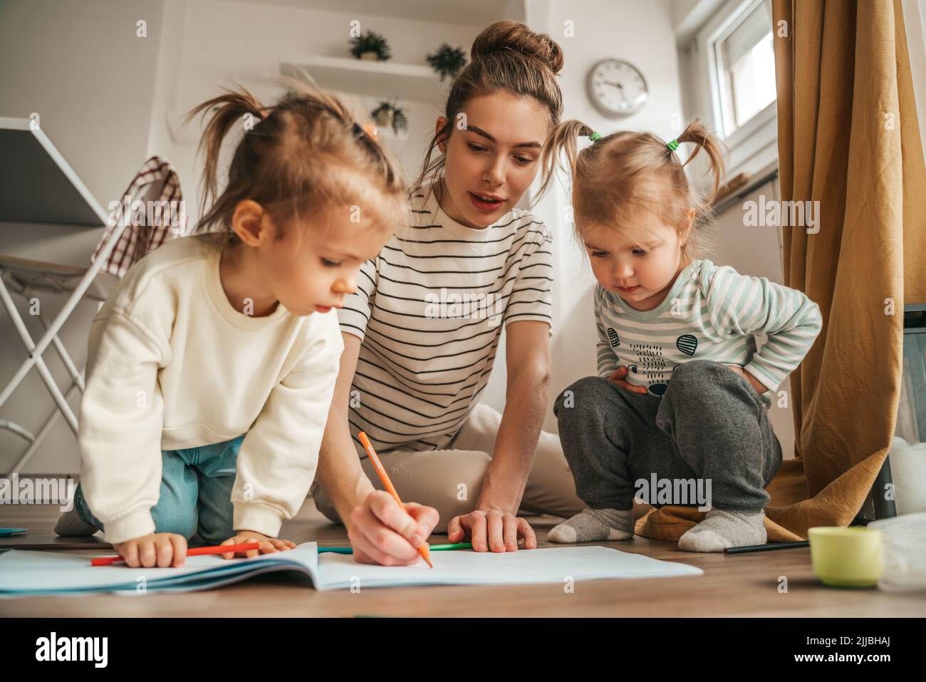 Young mother teaching her kids to draw Stock Photo - Alamy