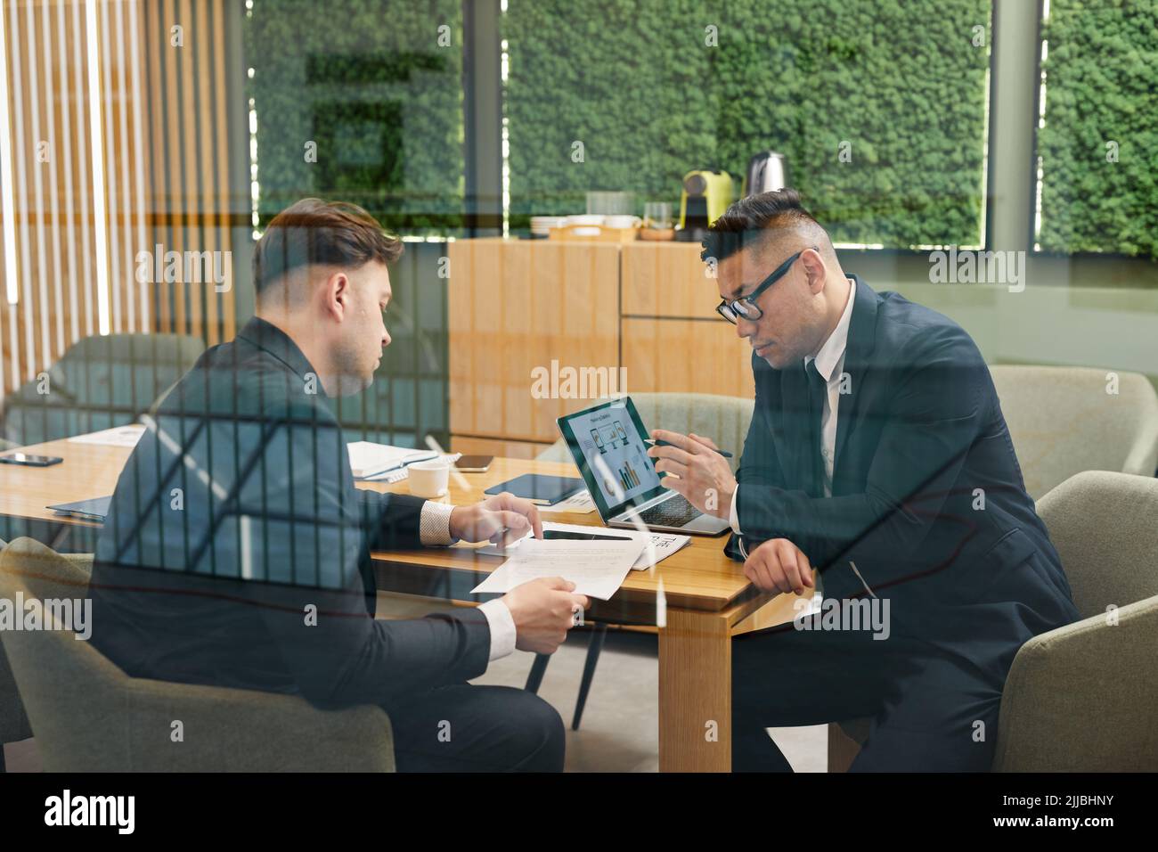 Two business people meeting in conference room and planning project ...