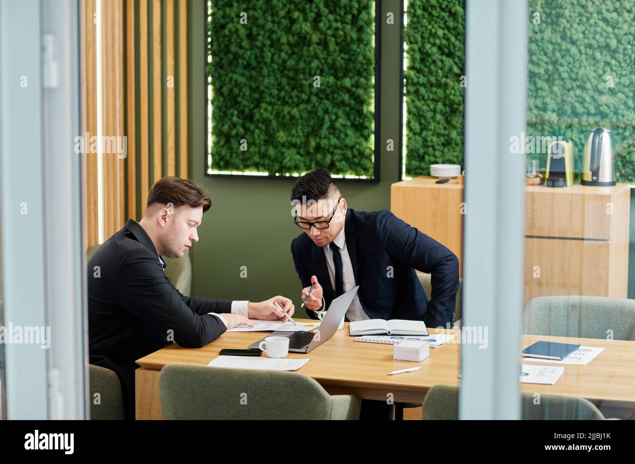 Portrait of two successful business people wearing suits during meeting ...