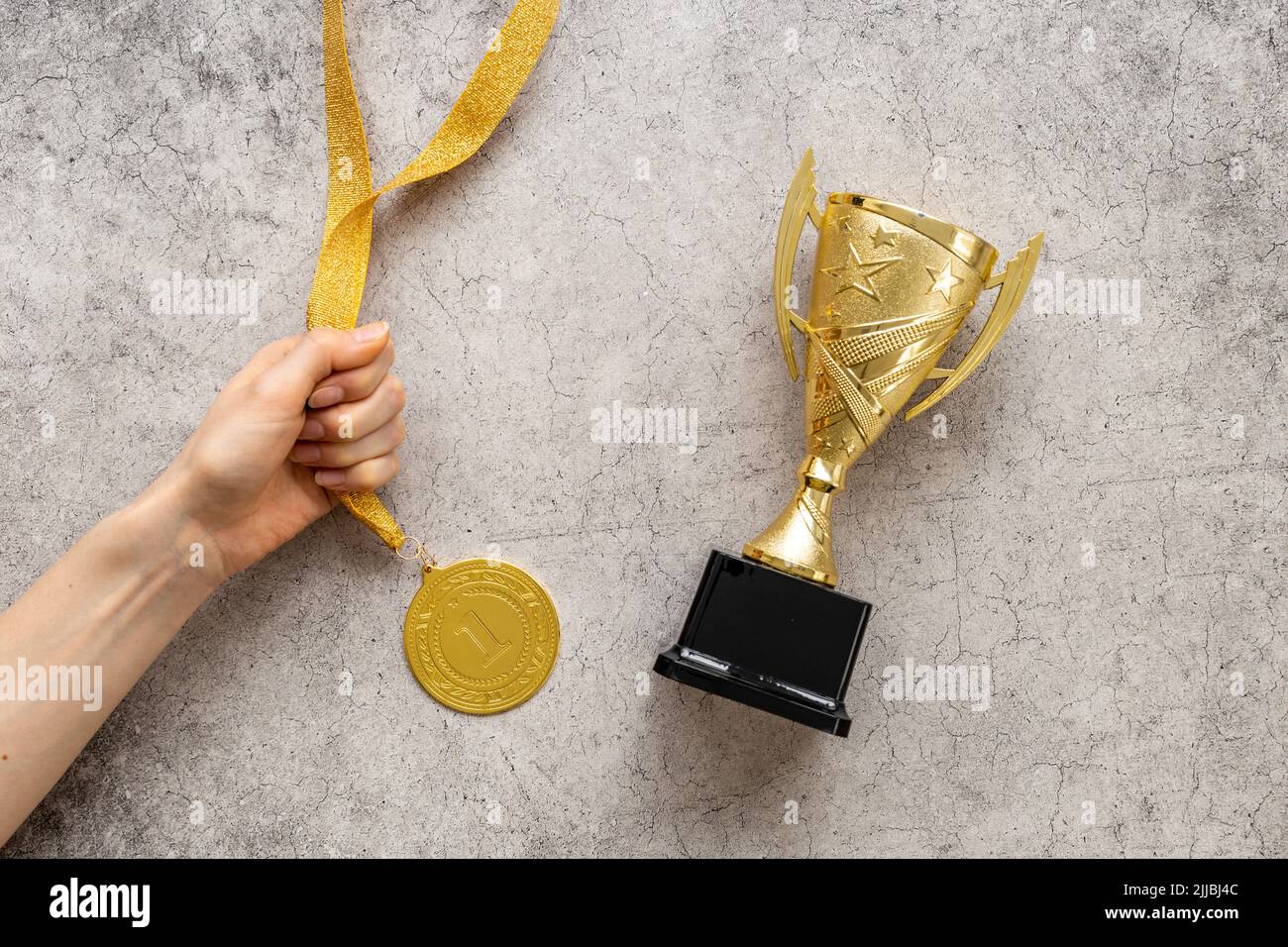 Winner and success concept. Hand holds gold medal trophy Stock Photo ...