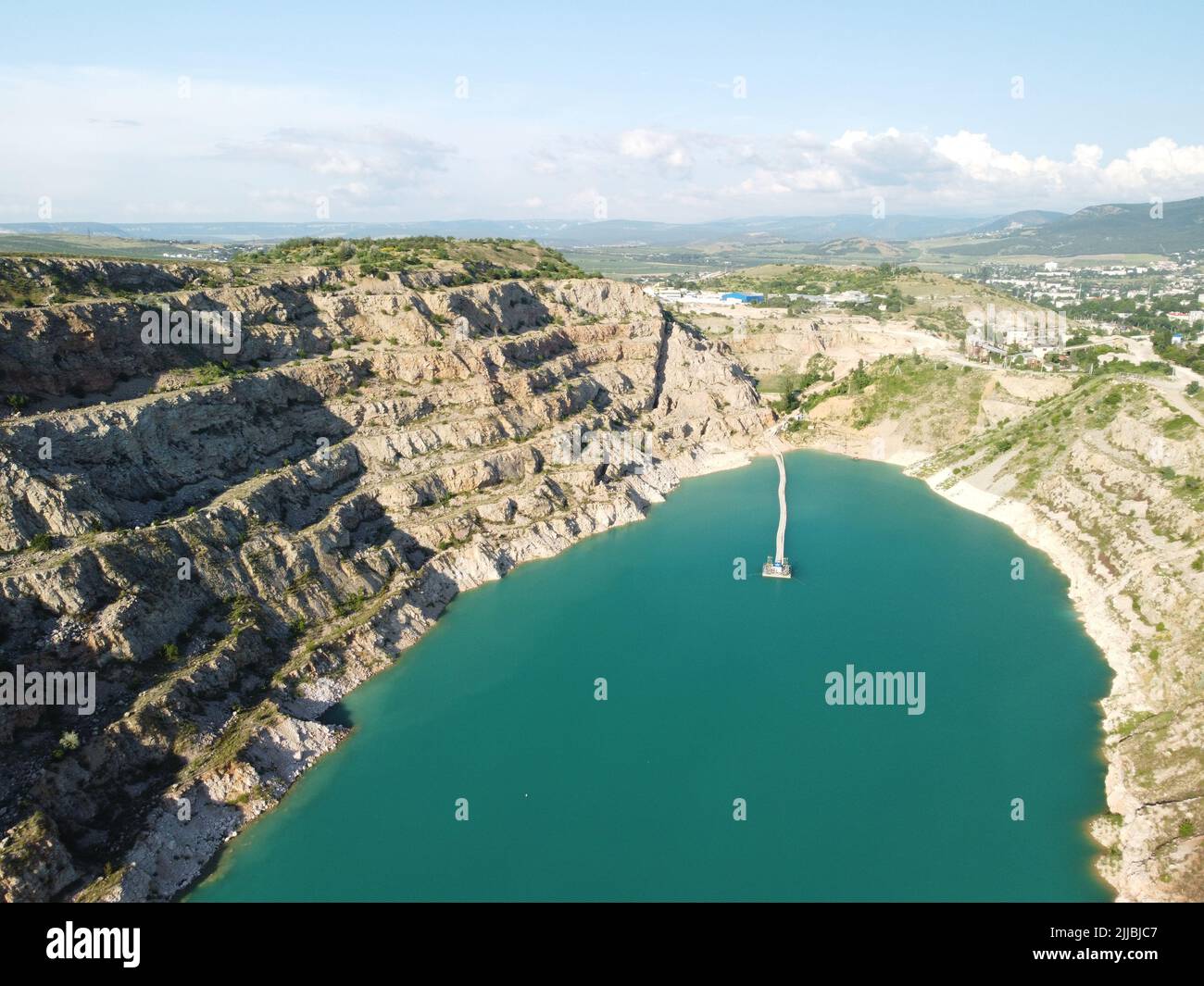 Aerial top view on opencast mining quarry with flooded bottom ...