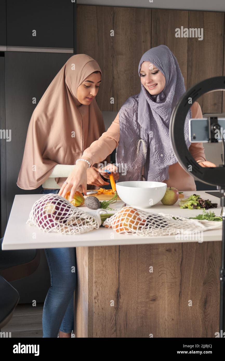 Two muslim food vloggers preparing a salad and recording a video Stock ...