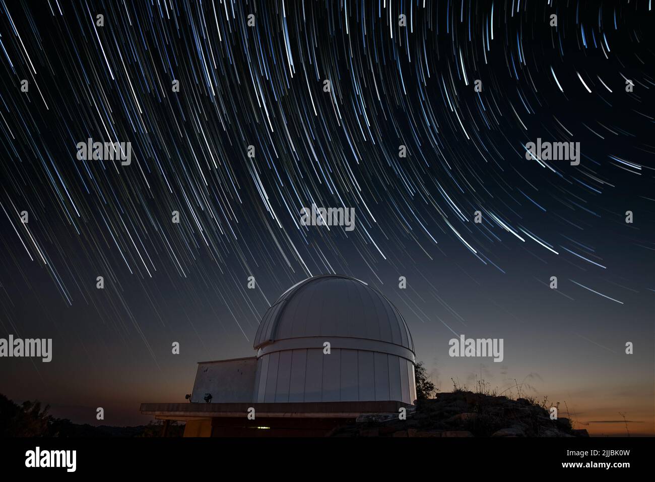 Astronomical observatory under star trails sky at night Stock Photo - Alamy