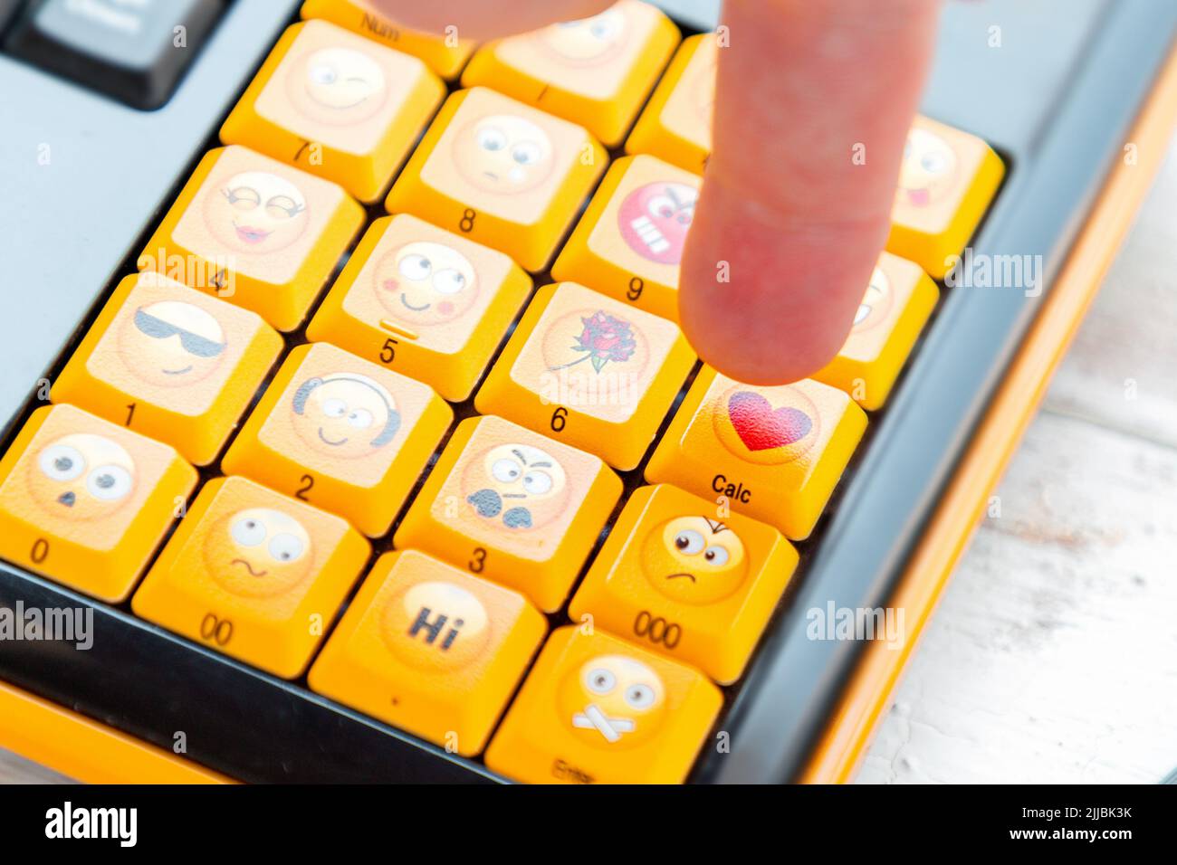 A finger presses a button with a heart sign on the keyboard. Close up ...
