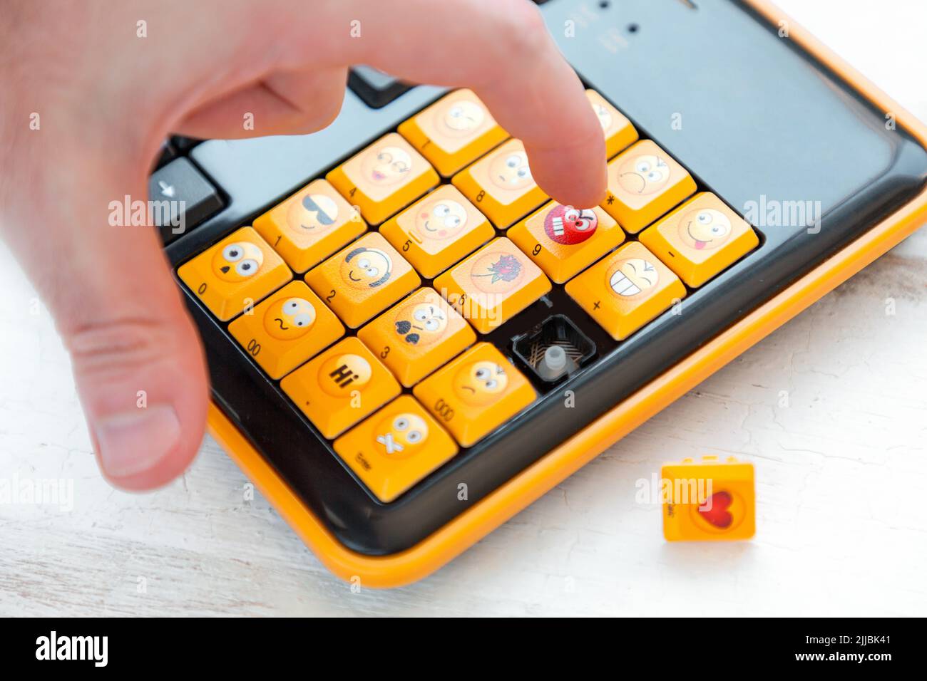 A male hand presses a button on the keyboard with an evil smiley face ...