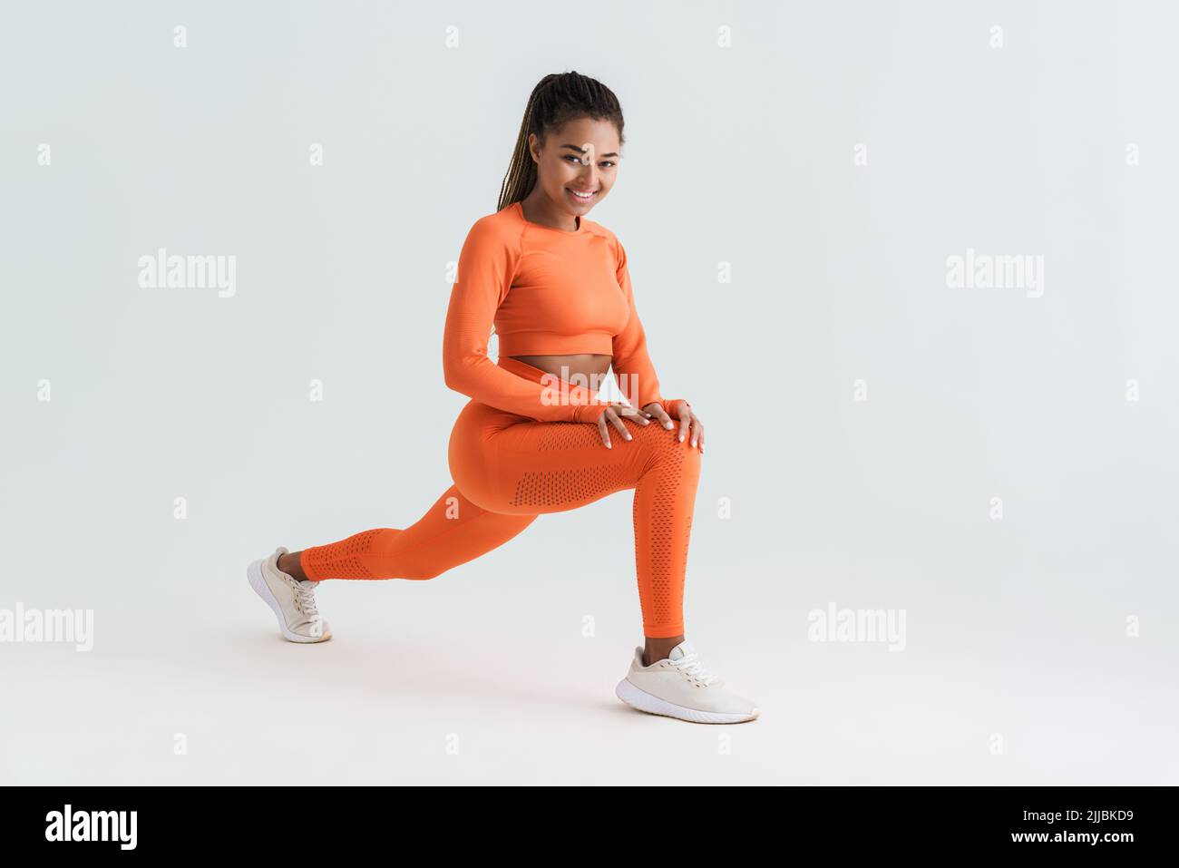 Black young sportswoman doing exercise while working out isolated over ...