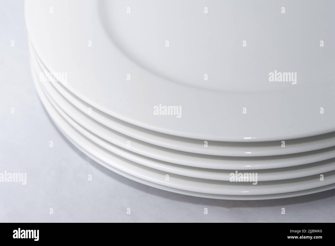 Stack of clean generic white ceramic dinner plates in a restaurant for ...
