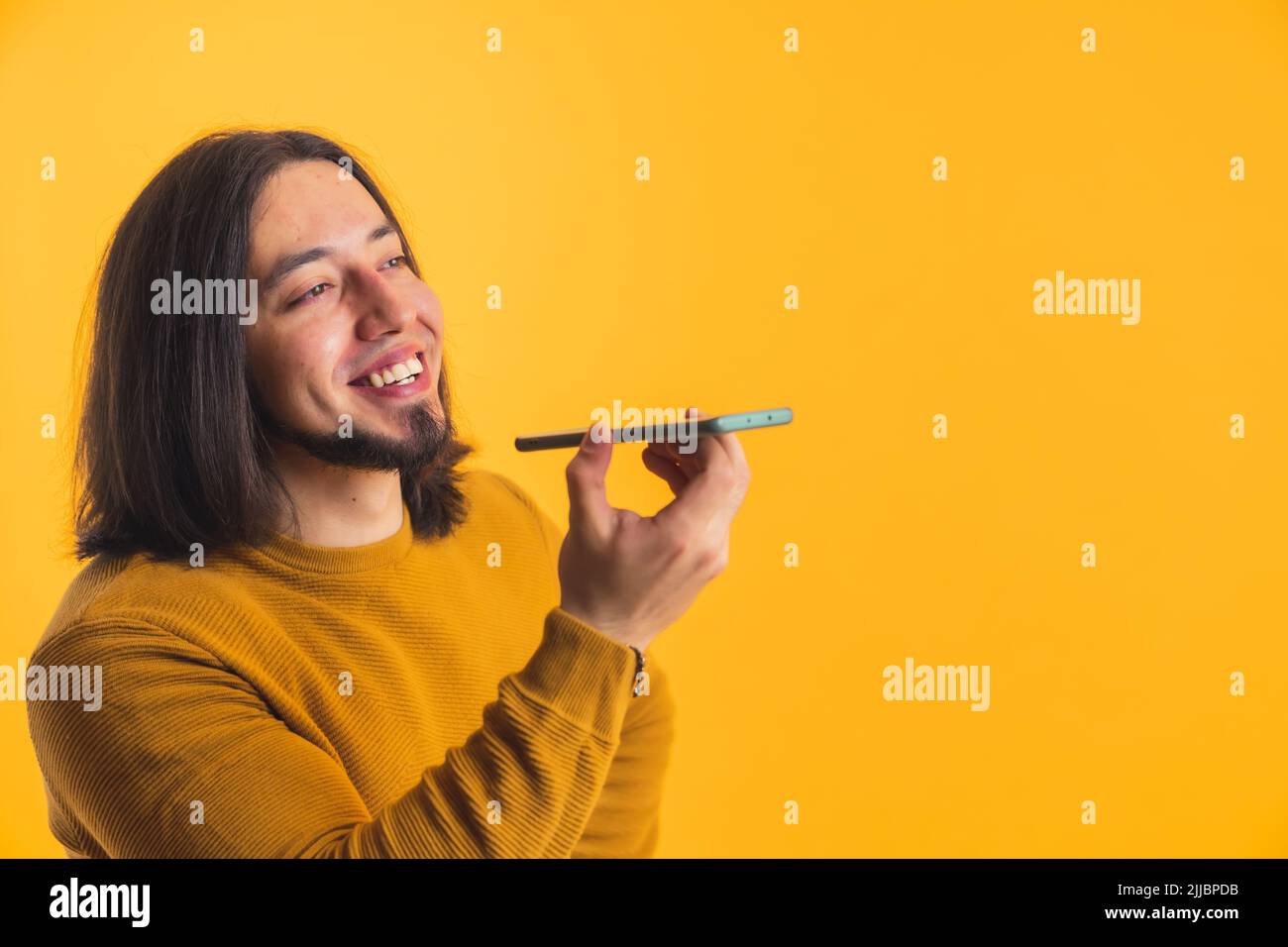 A happy long haired person on a yellow and orange background talking to ...