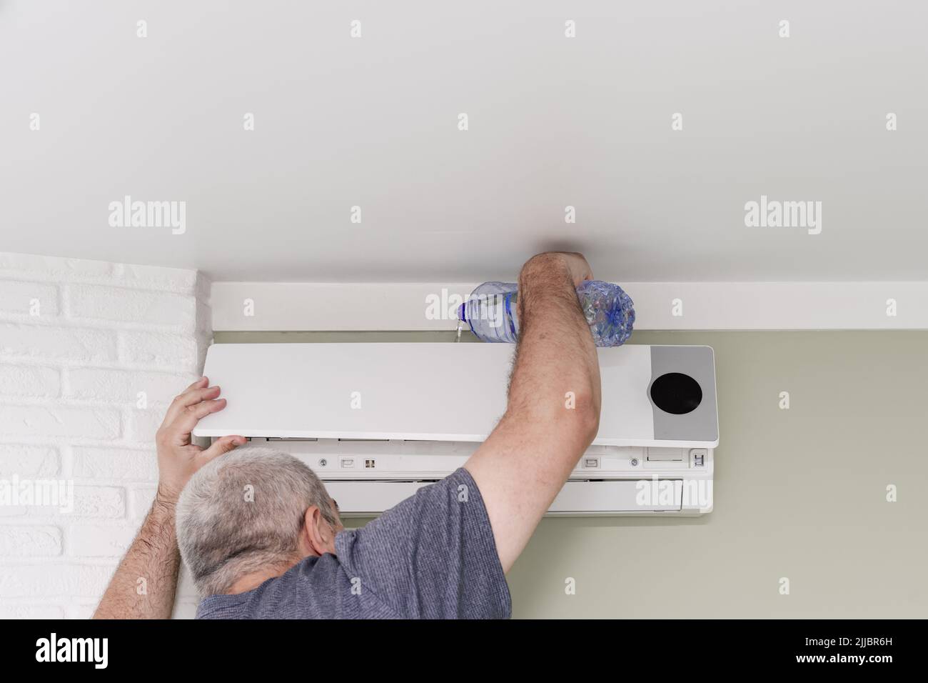 man cleans the air conditioning Stock Photo - Alamy