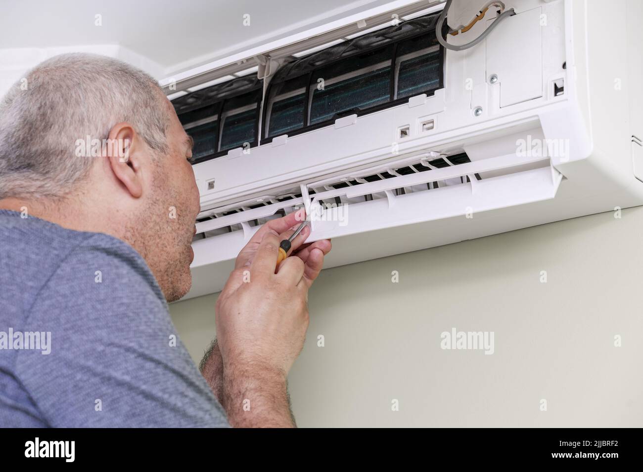 Technician repairing air conditioner using screwdriver hi-res stock ...