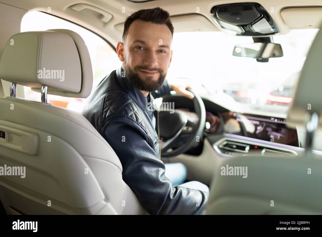 taxi driver turns over his shoulder as a passenger with a smile looking ...