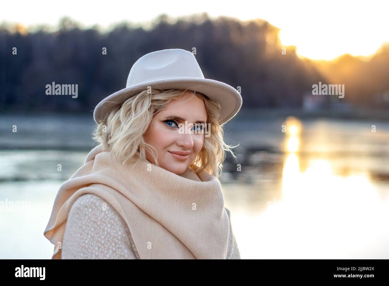 Portrait of a blonde woman with a mysterious modest smile in a hat and ...