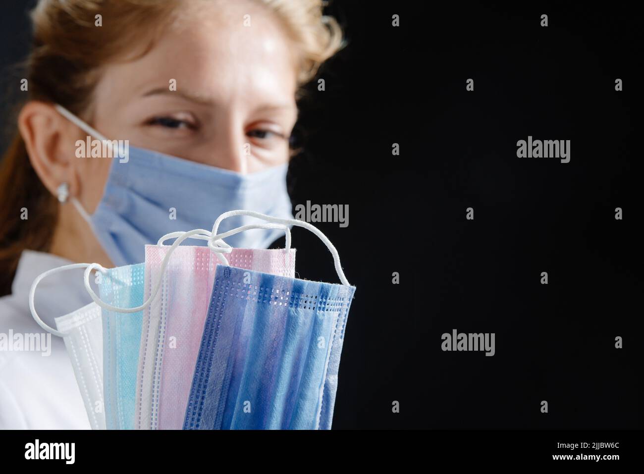 the doctor holds several masks of different colors in his hands. A ...