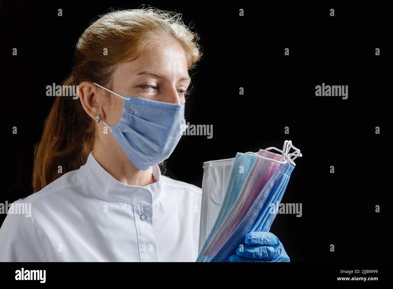 the doctor holds several masks of different colors in his hands. A ...