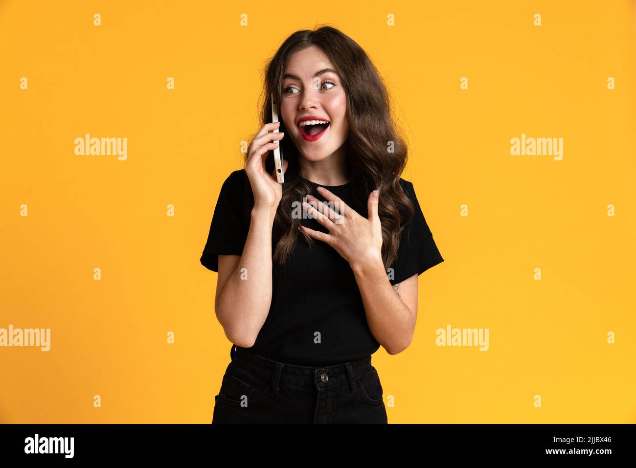 White excite woman gesturing while talking on mobile phone isolated ...