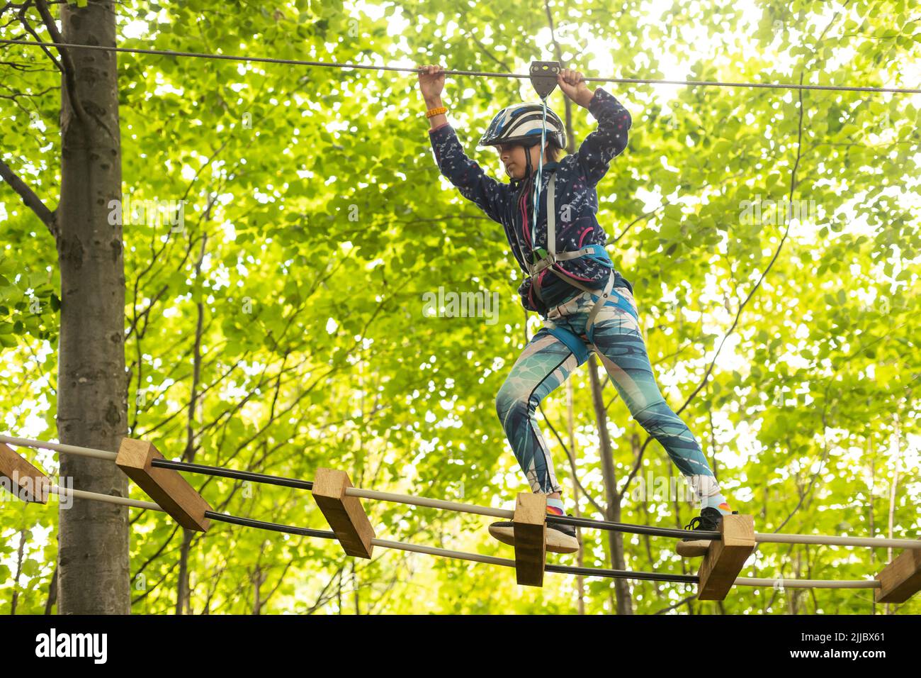 Adorable little girl enjoying her time in climbing adventure park on ...