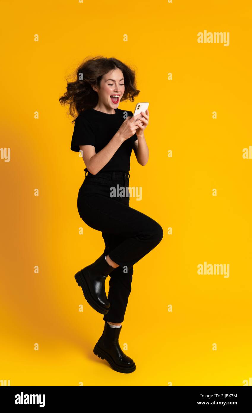 White excited woman making fun while using mobile phone isolated over ...