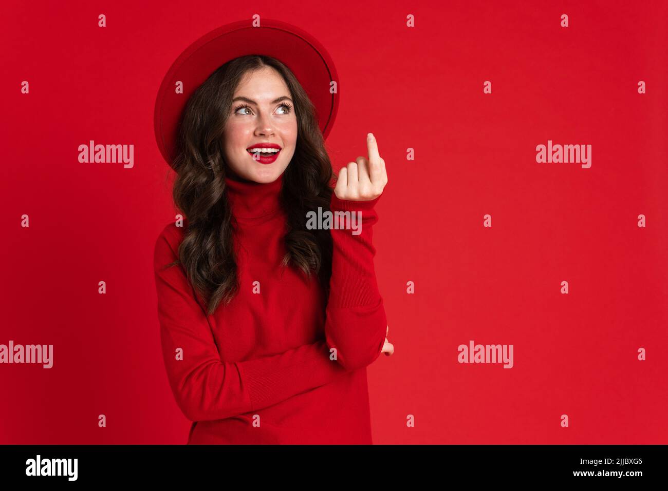 White woman wearing hat pointing finger upward and smiling isolated ...