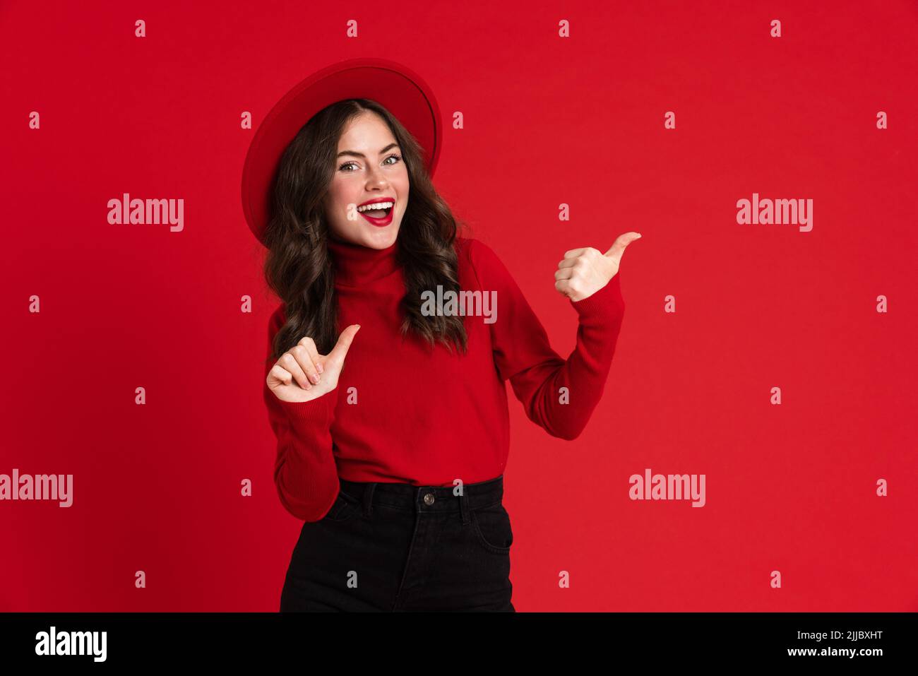 White woman wearing hat smiling and pointing fingers aside isolated ...