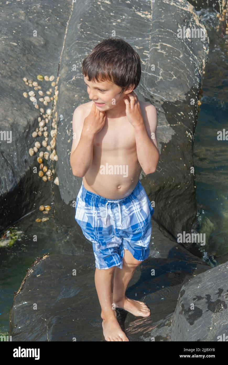 Boy playing on rocks Stock Photo - Alamy
