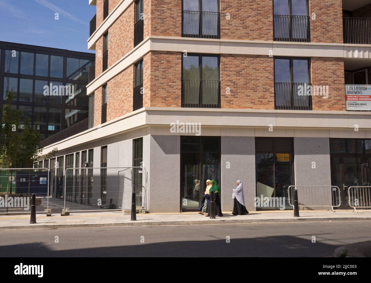 Muslim women walking past new residential and commercial buildings near ...