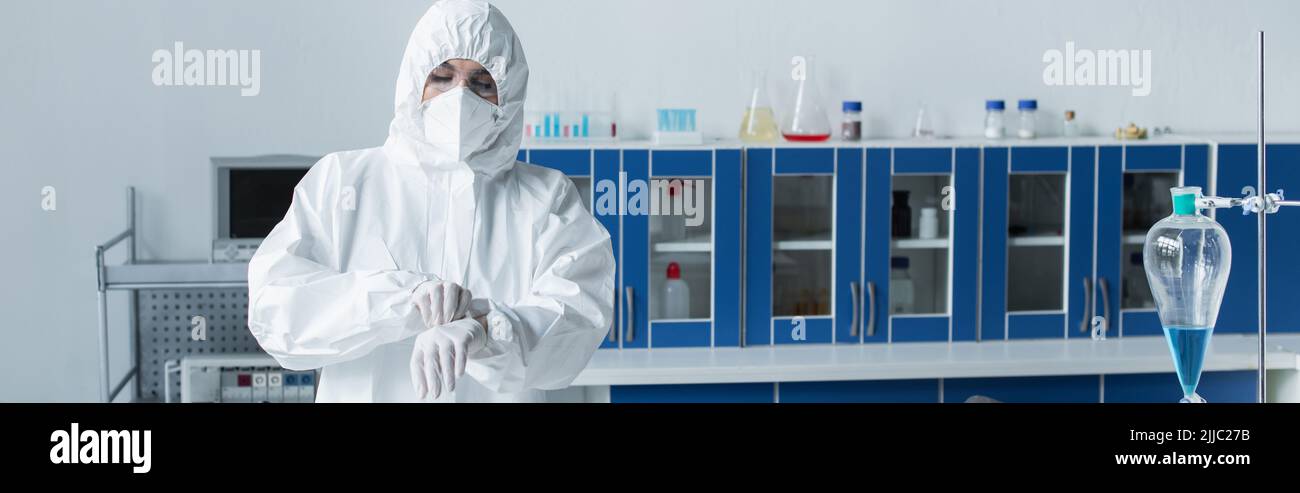 Scientist in hazmat suit wearing latex gloves in lab, banner Stock ...